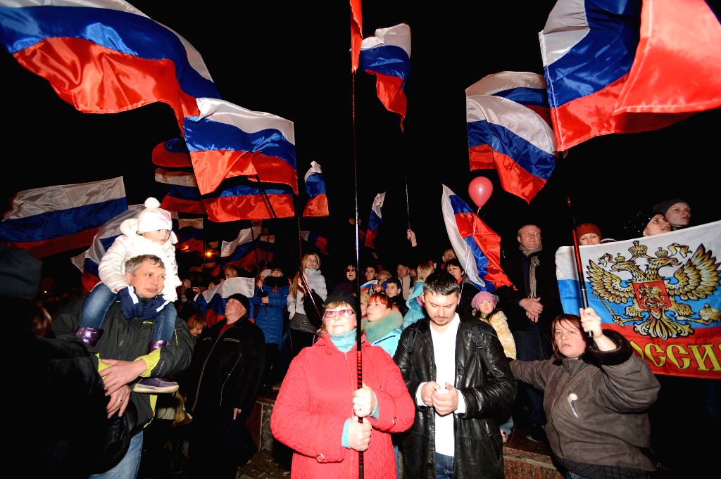Crimeans holding russian flags celebrate in front of the parliament ...