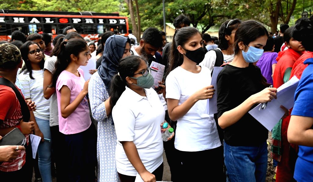 Students wait outside before entering the examination centre to appear ...