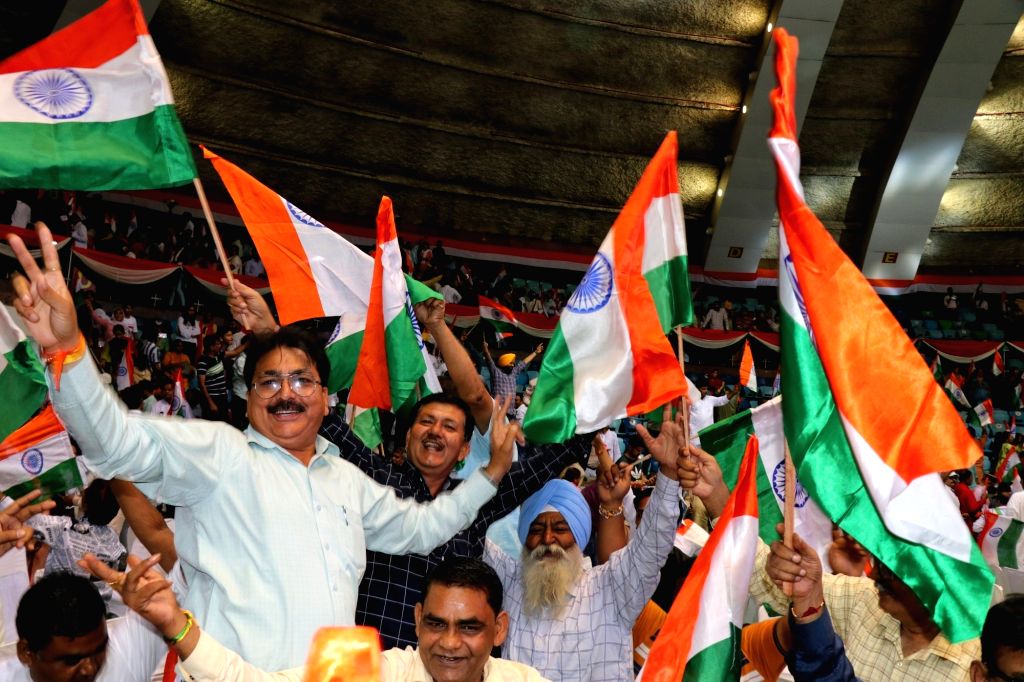 Supporters hold tricolor flags during the launch of a national mission