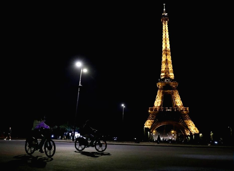 The lighting Eiffel Tower is seen in Paris