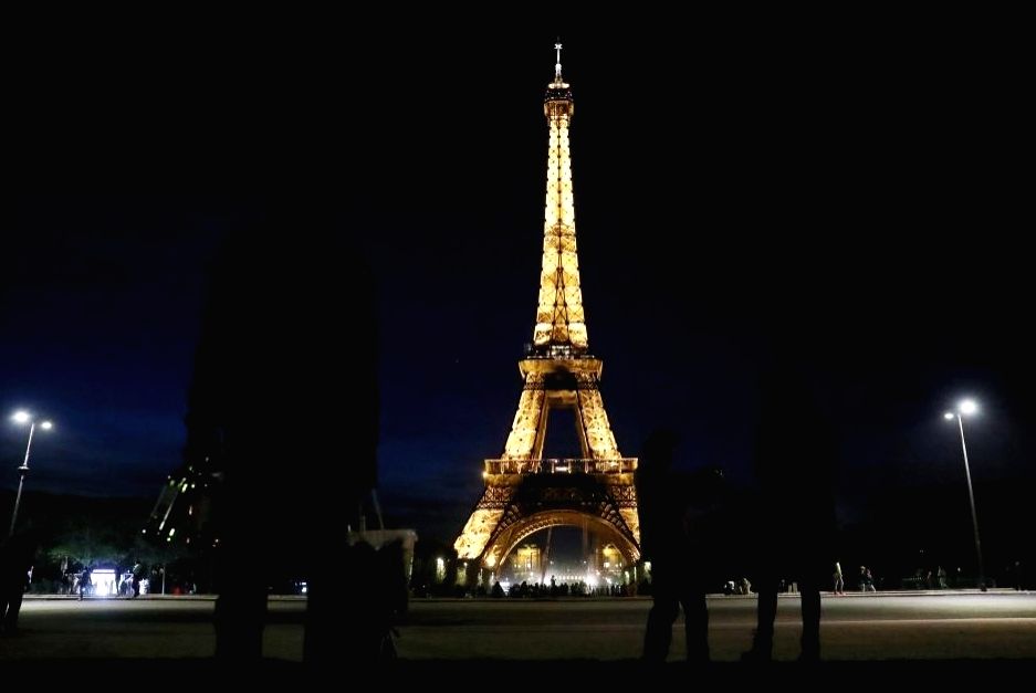 The lighting Eiffel Tower is seen in Paris