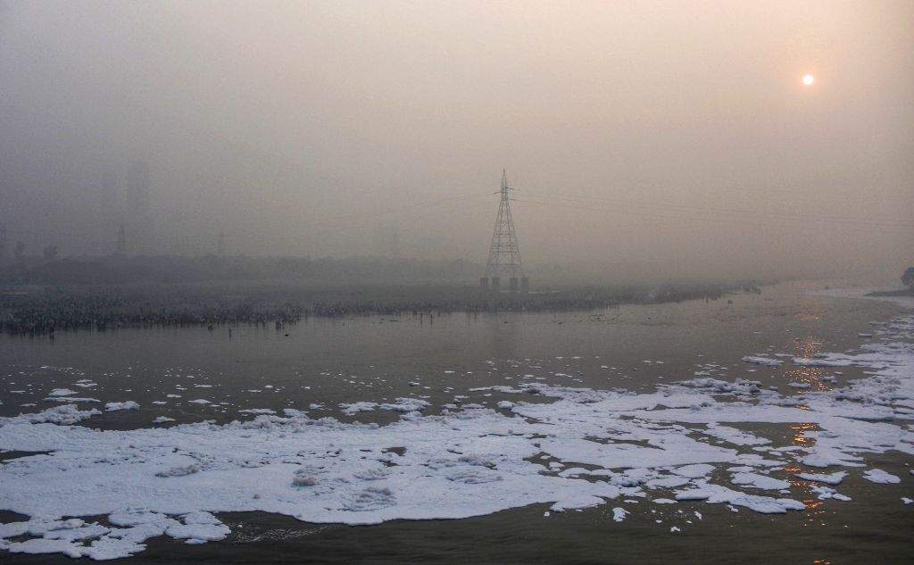 Thick smog blankets the sky as toxic foam floats on the Yamuna River