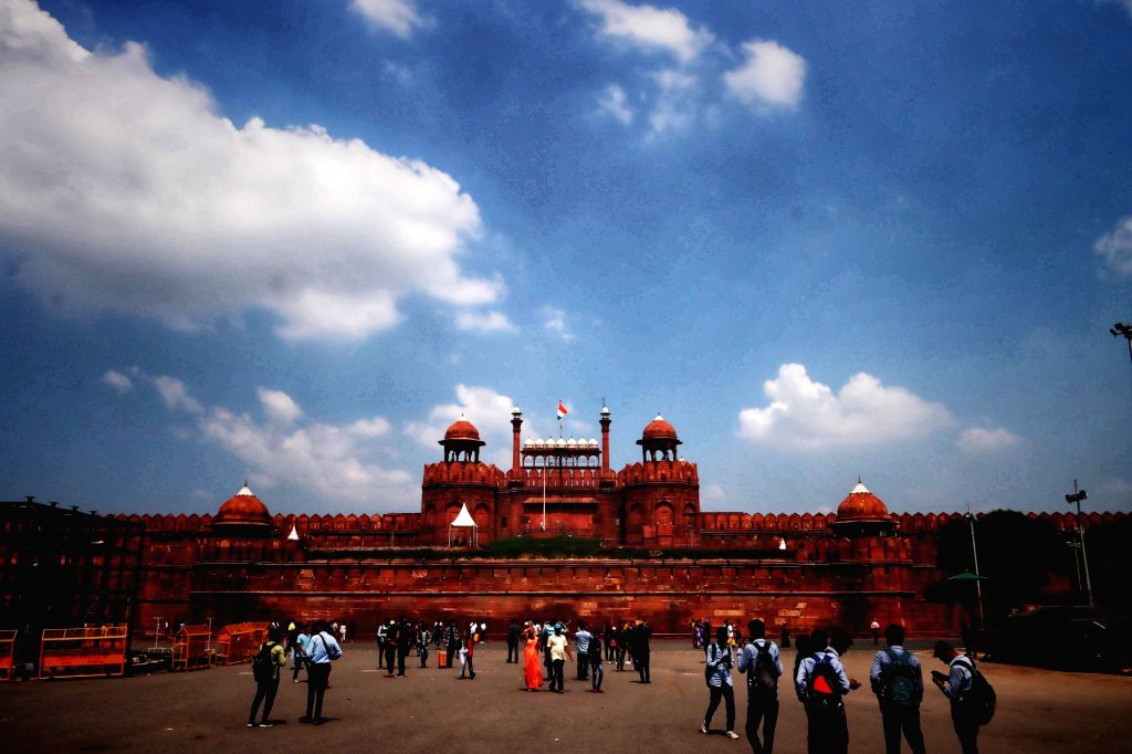 Tourists visit as clouds hover over the Red Fort