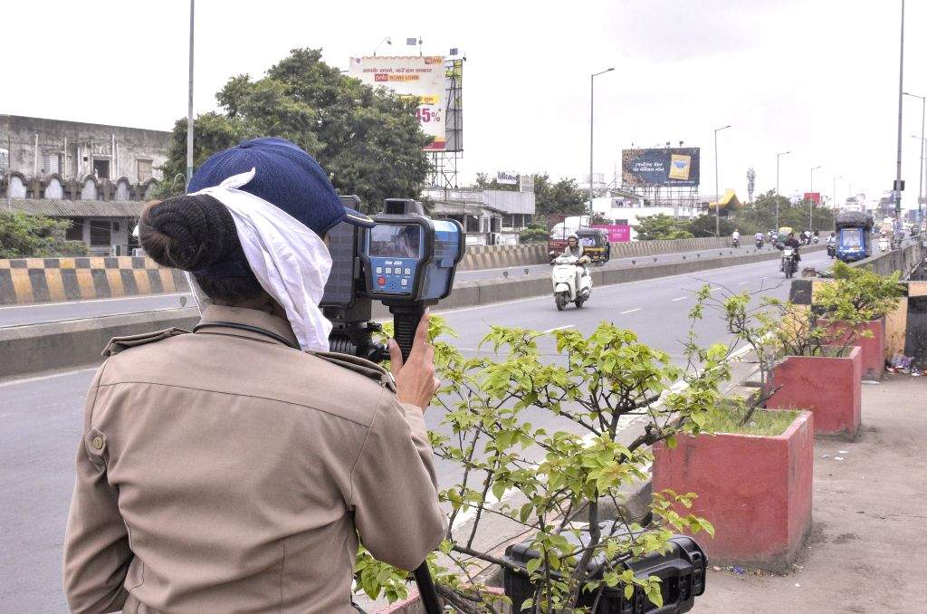 Traffic police monitor vehicle speeds using LIDAR speed gun