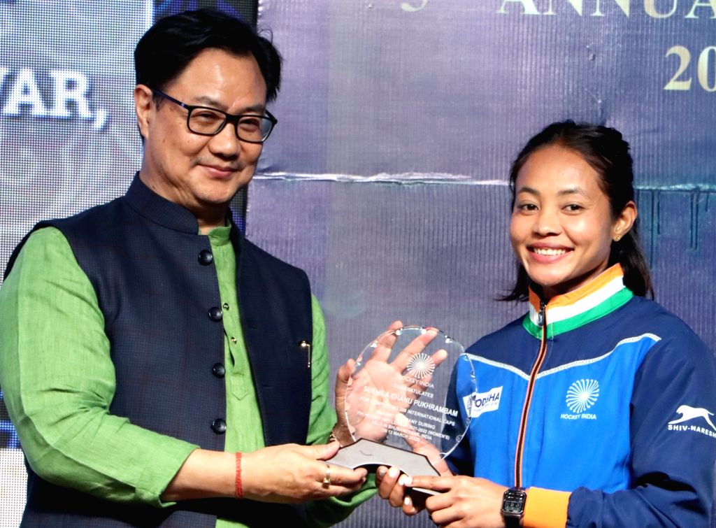 Union Law Minister Kiren Rijiju honours a hockey player