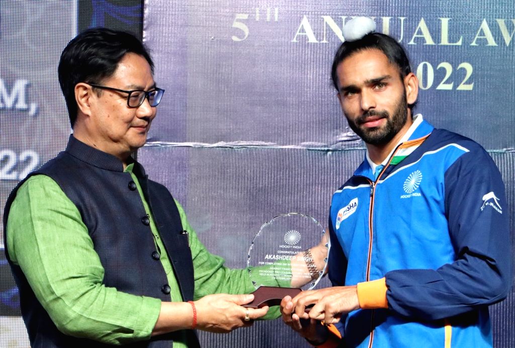 Union Law Minister Kiren Rijiju honours a hockey player