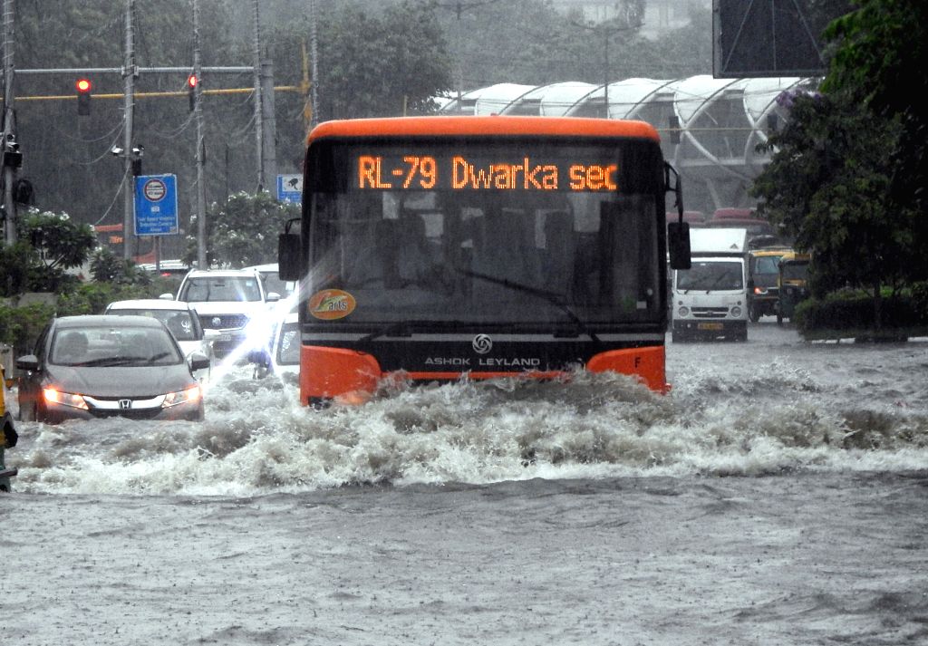 Vehicles move through waterlogged road as monsoon rain lashes