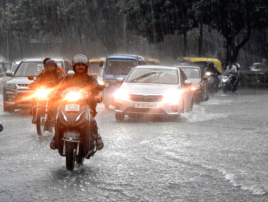 Vehicles navigate through waterlogged road