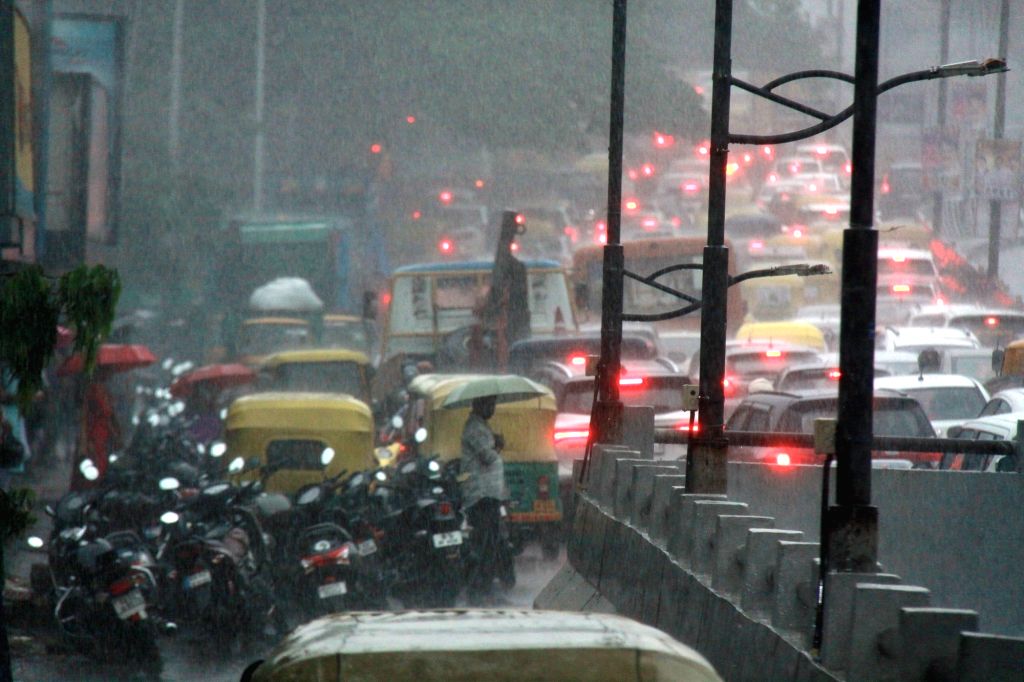 Vehicles ply on road as heavy rain lashes