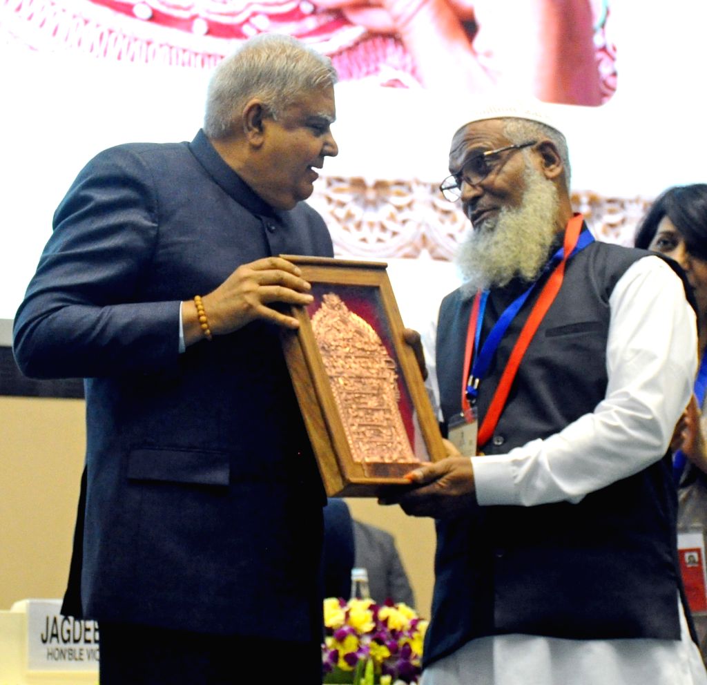 Vice President of India Jagdeep Dhankhar presents an award to a beneficiary