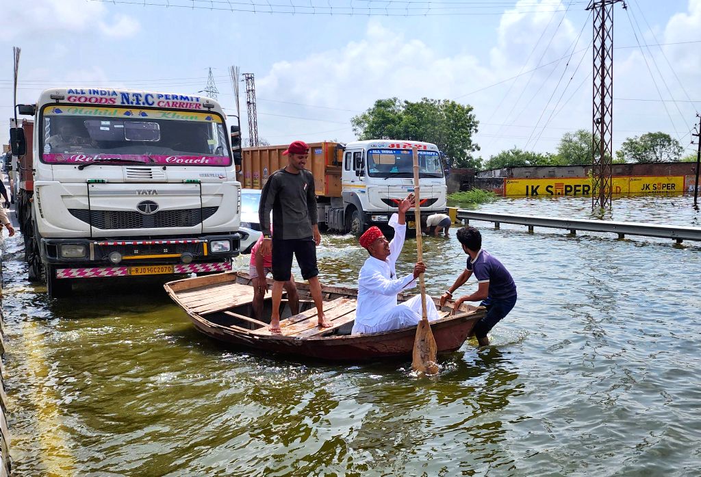 Villagers taking a boat ride through a waterlogged road