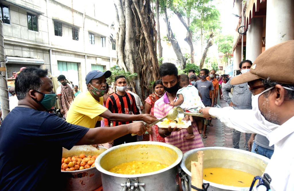 Volunteers distribute free food to poor and needy people during ...