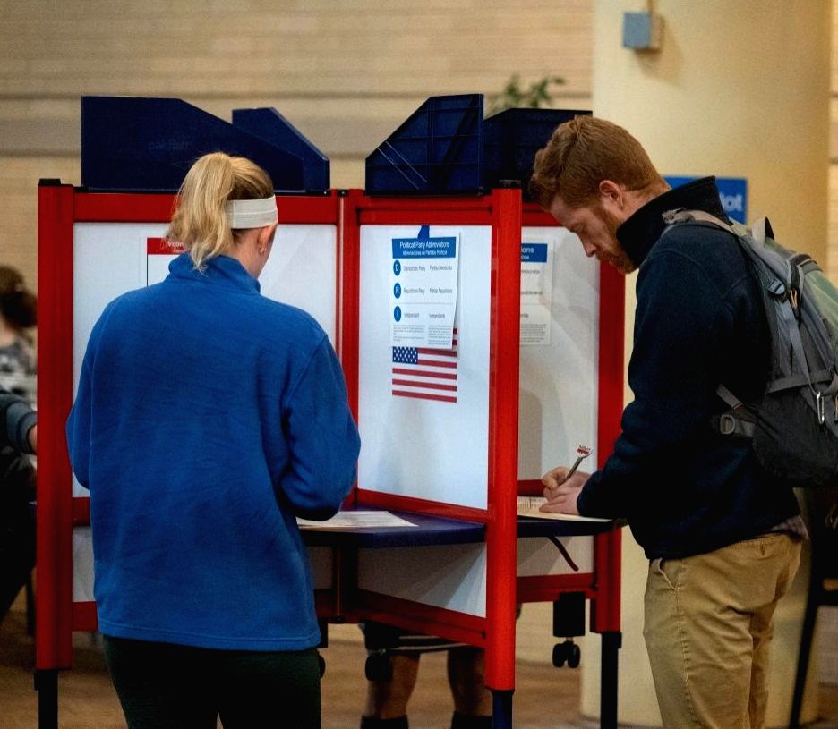New York :Voters fill in their ballots at a polling station in New York