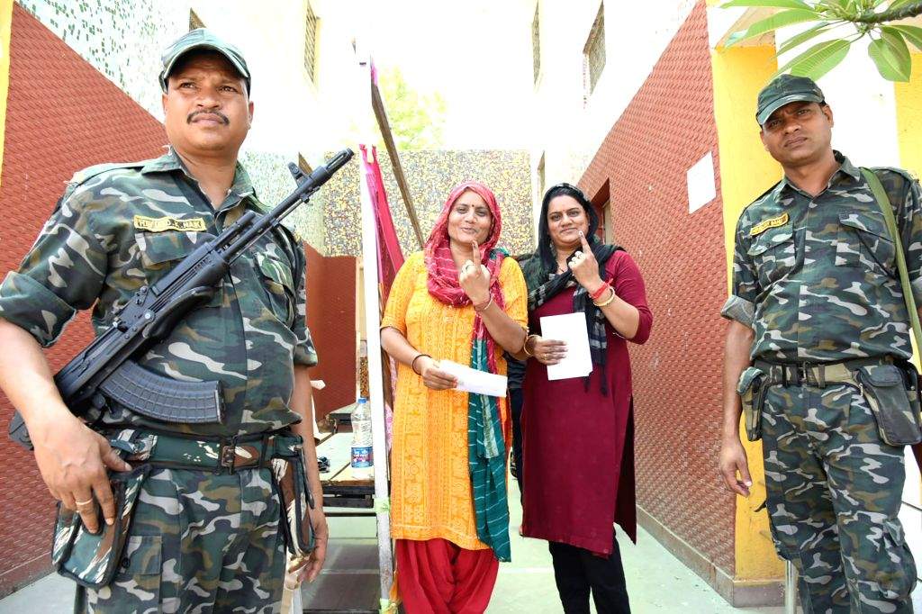Voters showing mark of indelible ink after casting their votes at a ...