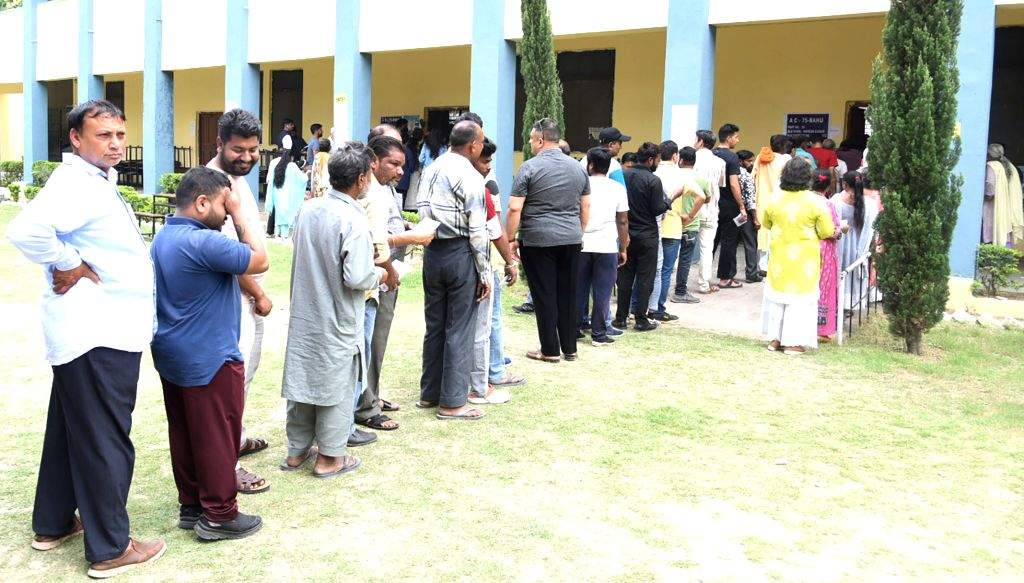 Voters stand in the queue to cast their votes, at a polling booth ...