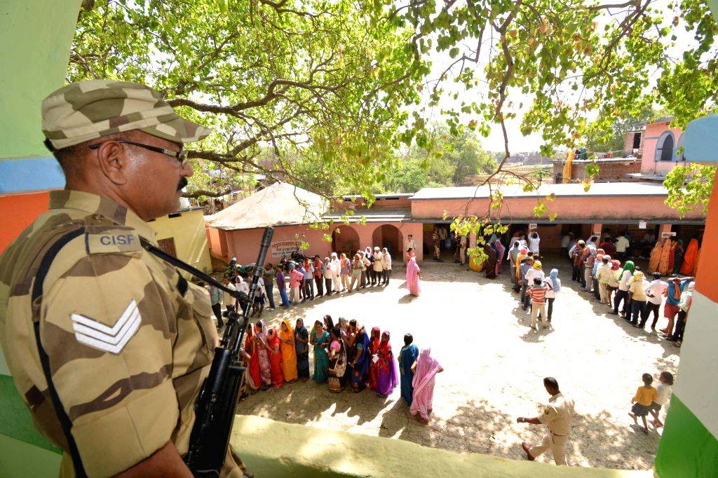 Voters wait in a queue at a polling station to cast their votes for the ...