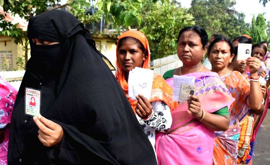 Voters wait in a queue at a polling station to cast their votes for the ...