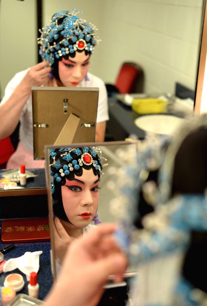 Peking Opera actor Hu Wenge prepares to perform