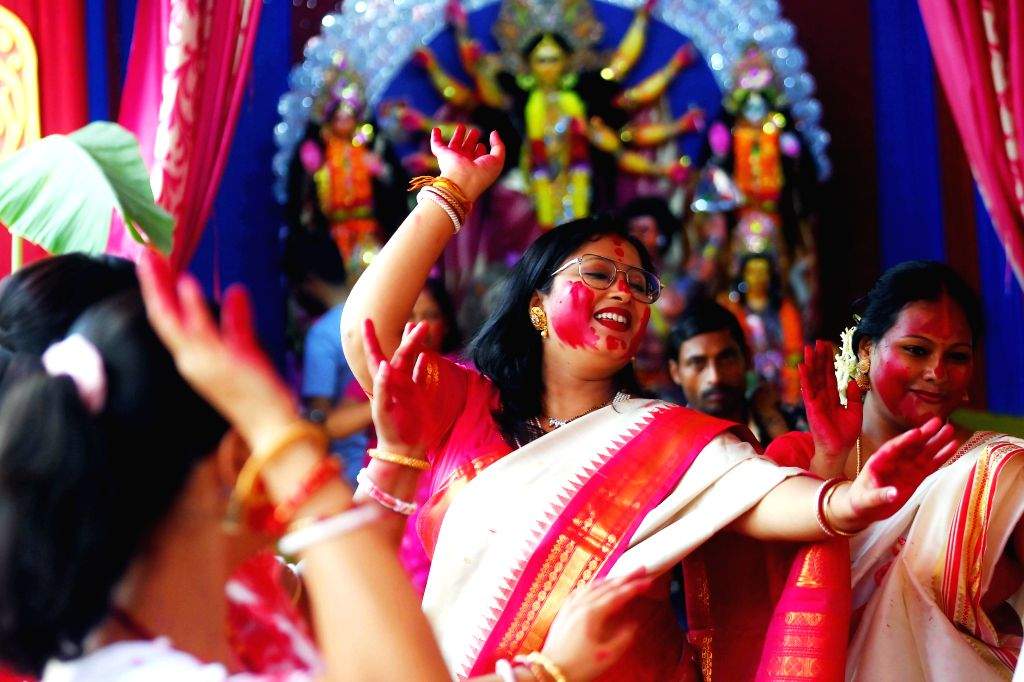 Women apply vermillion powder on each other as they participate in ...