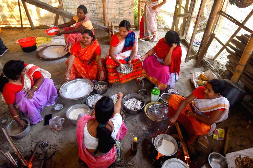 Women busy preparing traditional pithas (delicacies) and other items ...