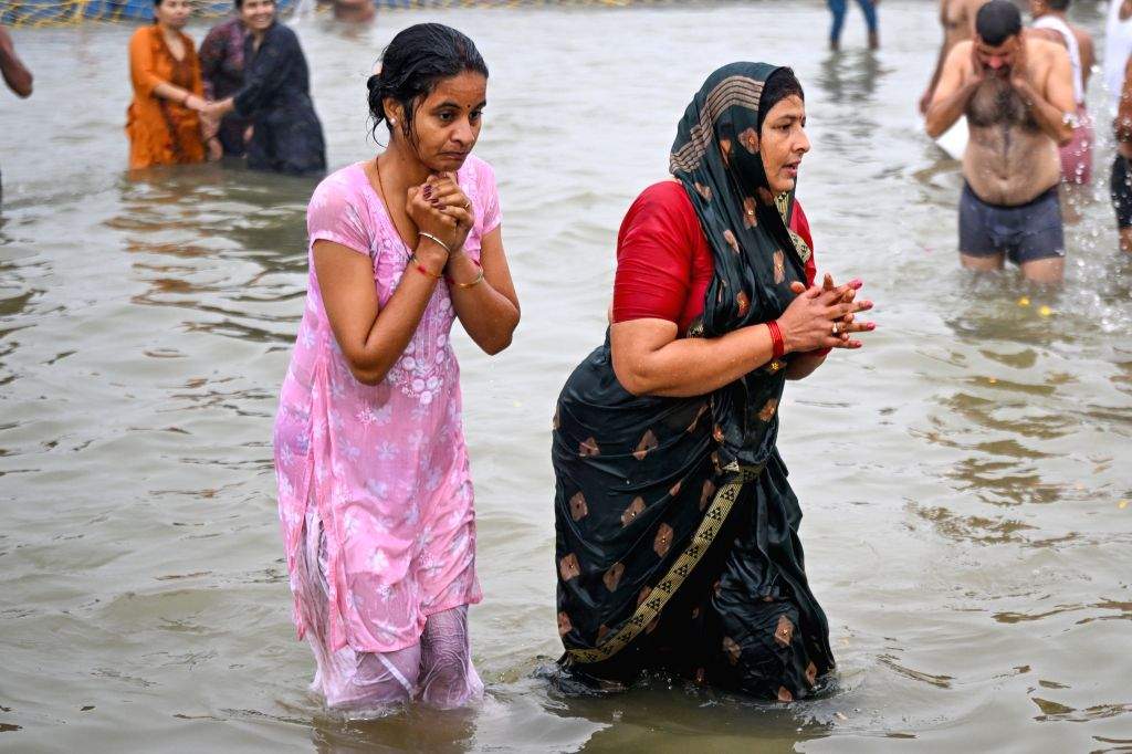Women devotees take a holy dip at the Triveni Sangam
