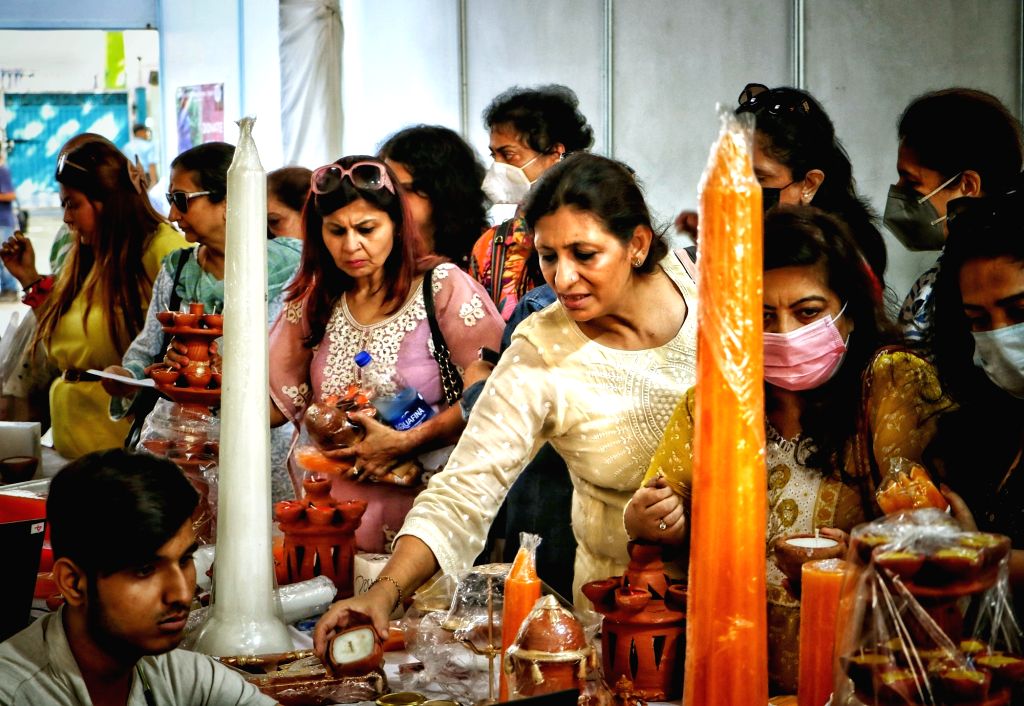 Women purchase decorative items from a shop at Diwali Bazar 2022