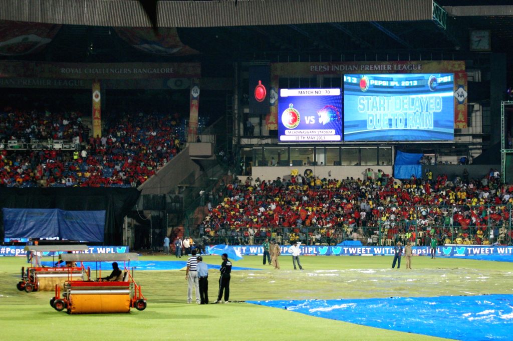 Workers covering pitch due to rain during IPL cricket match between ...