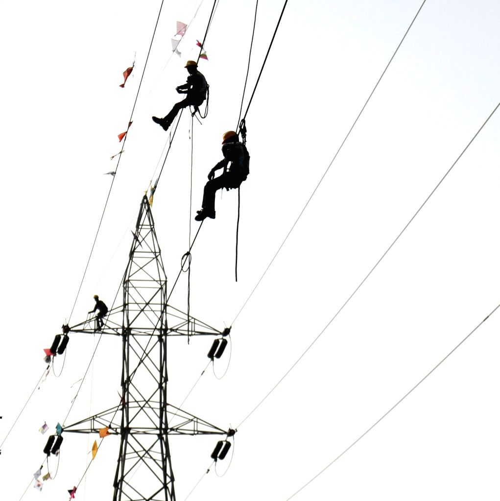 Workers remove kites stuck in high tension wire