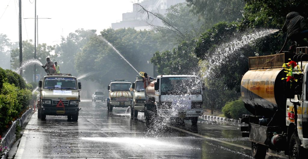 :Workers spray water to curb air pollution as a thick layer of smog ...