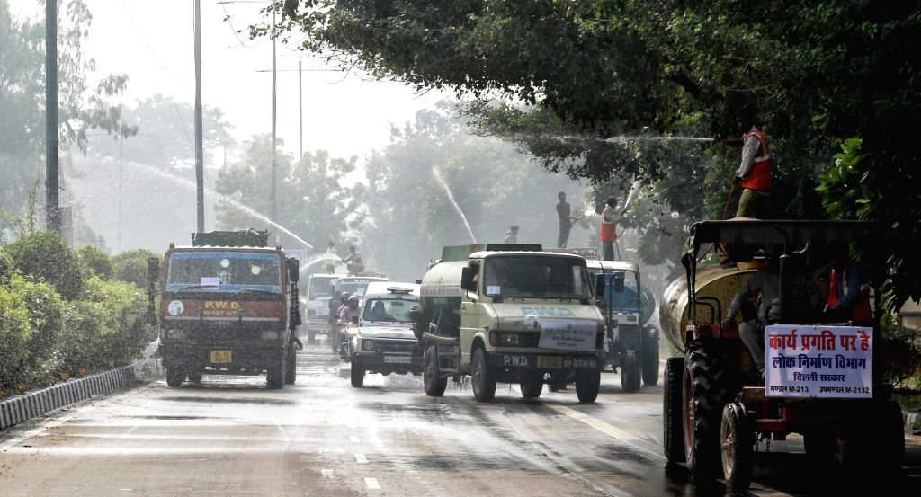 :Workers spray water to curb air pollution as a thick layer of smog ...