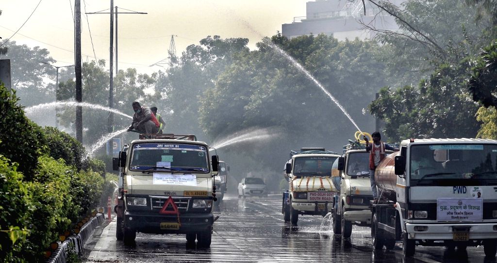 :Workers spray water to curb air pollution as a thick layer of smog ...