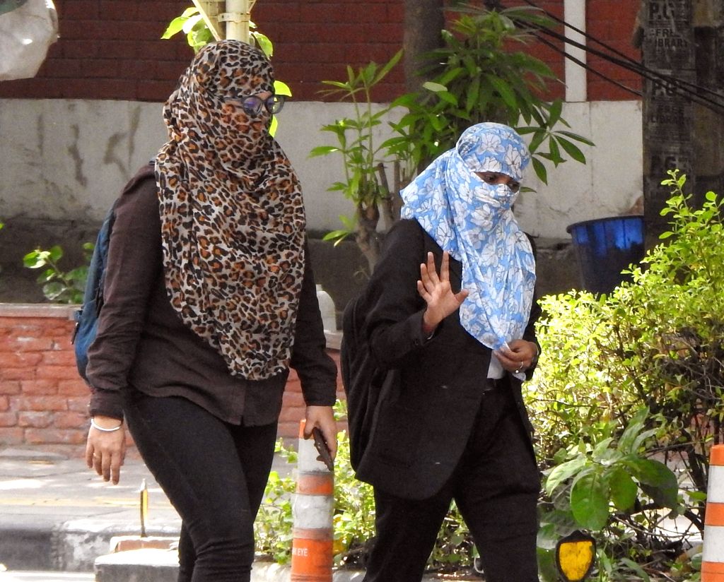 New Delhi : Young women wear scarves to protect themselves from the ...
