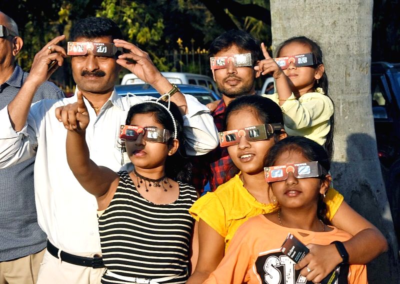 Children wearing eclipse viewers try to watch the partial solar eclipse