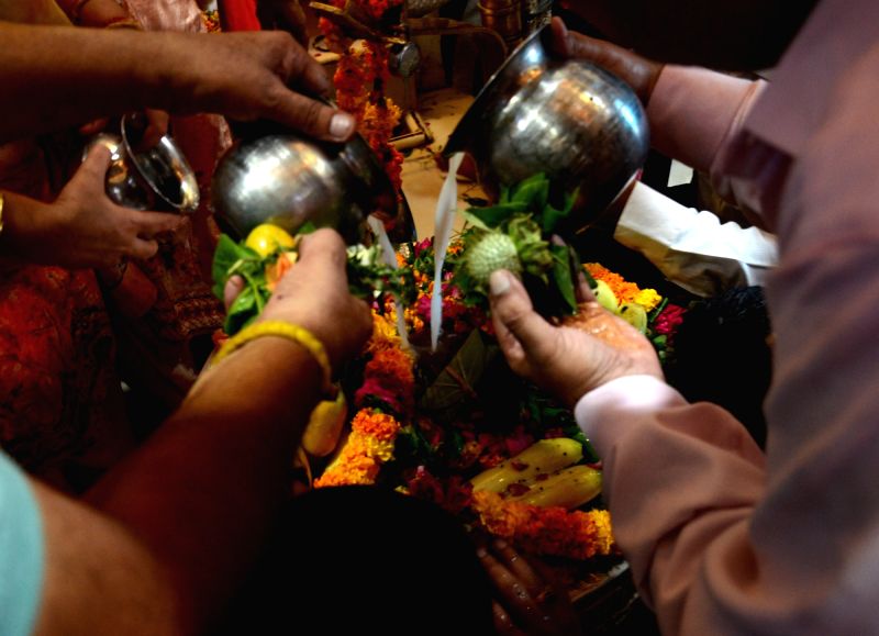 Hindu devotees perform rituals pouring milk and water on a Shiva Lingam ...