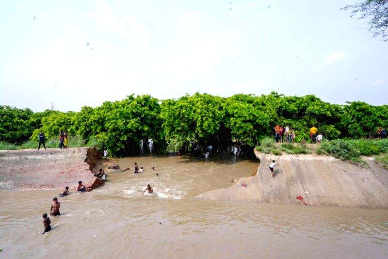 Residentials take bath at the Munak Canal following a breach in the ...